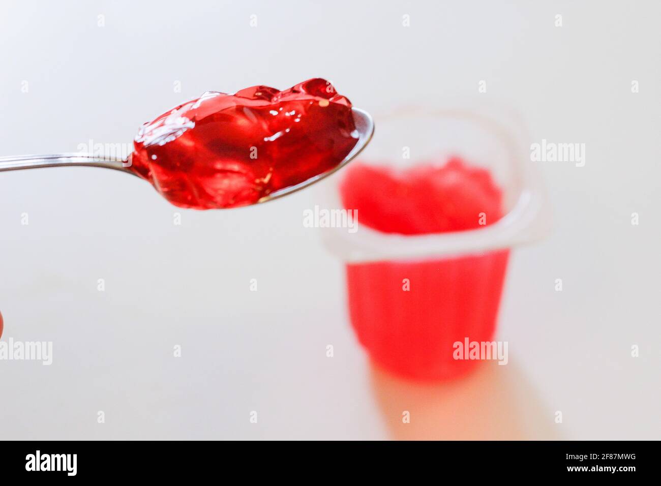 Spoon with red jelly in a white background Stock Photo - Alamy