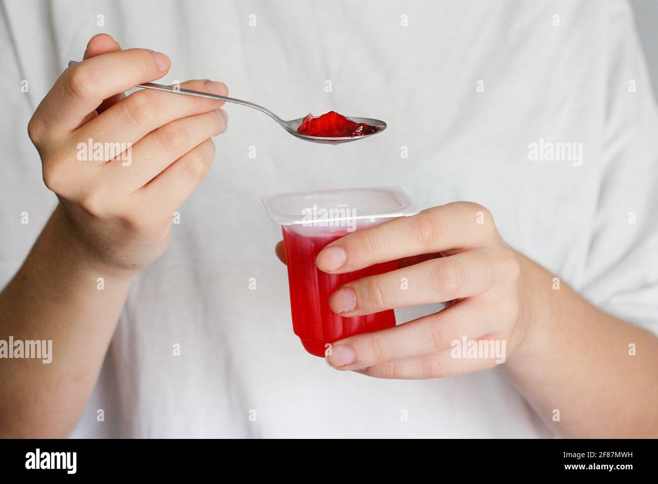 Woman eating red jelly Stock Photo - Alamy