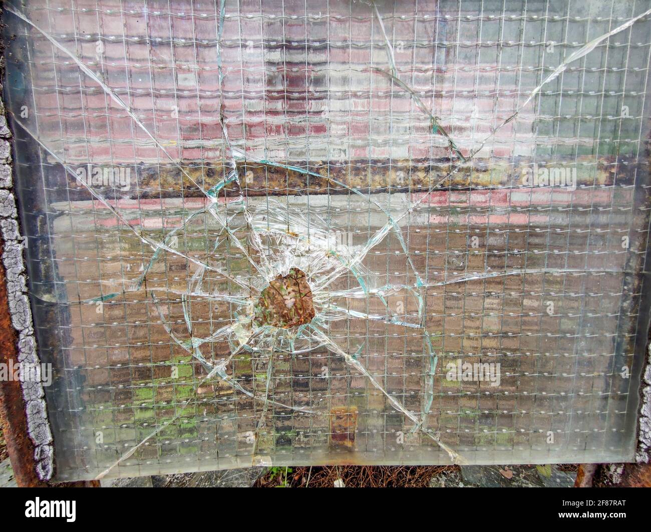 real gun bullet broken window glass Stock Photo - Alamy