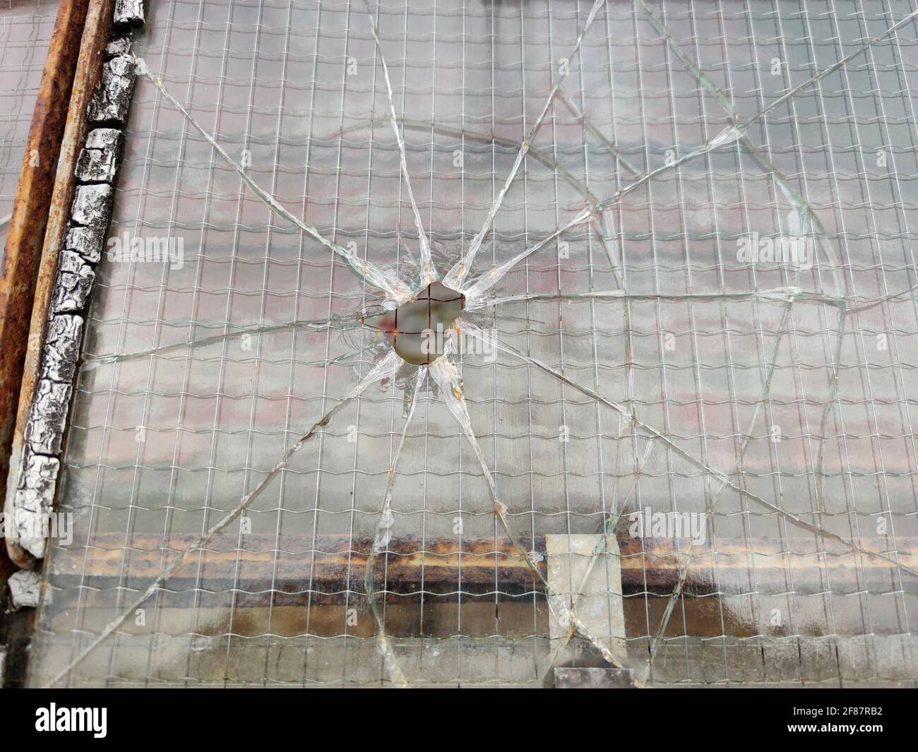 real gun bullet broken window glass Stock Photo - Alamy