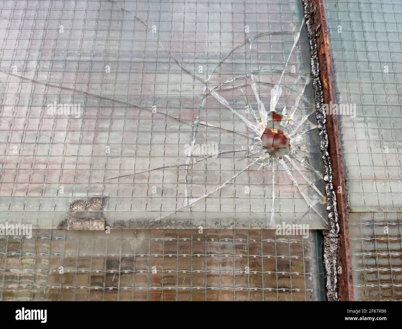 real gun bullet broken window glass Stock Photo - Alamy