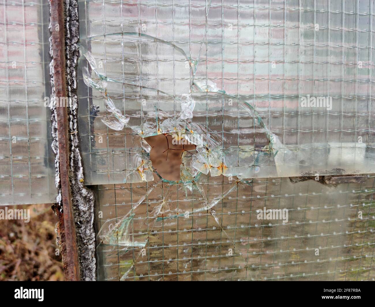 real gun bullet broken window glass Stock Photo - Alamy