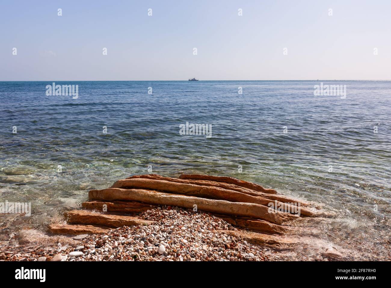 Seascape with pebble shore and ship at the sea Stock Photo - Alamy