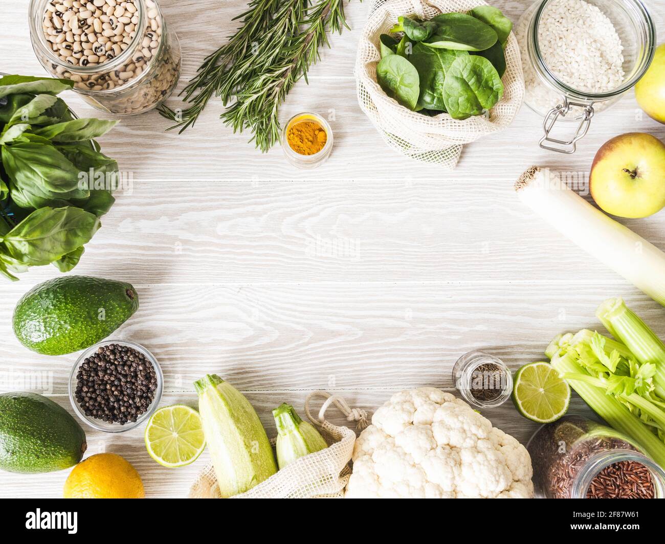 Fresh raw vegetables, fruits, grains and spices on wood light ...