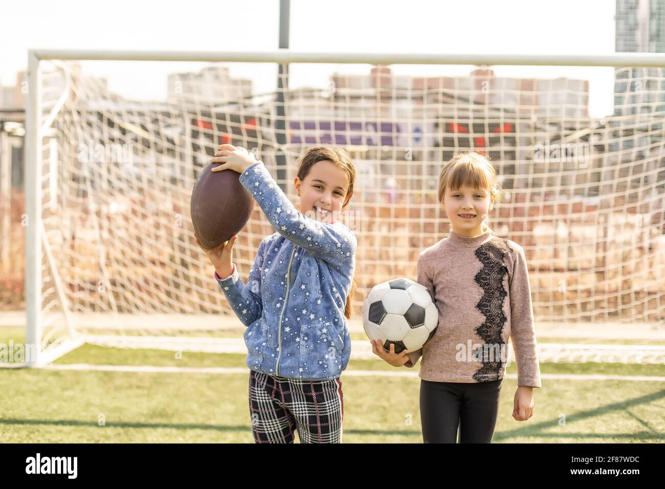 Kids play football on outdoor field. Children score a goal at soccer ...