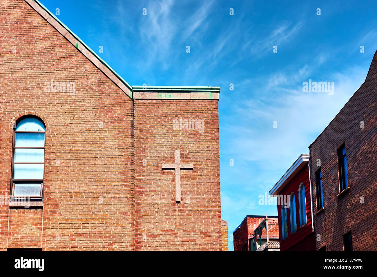 Embossed cross symbol on the exterior brick wall of a church building ...
