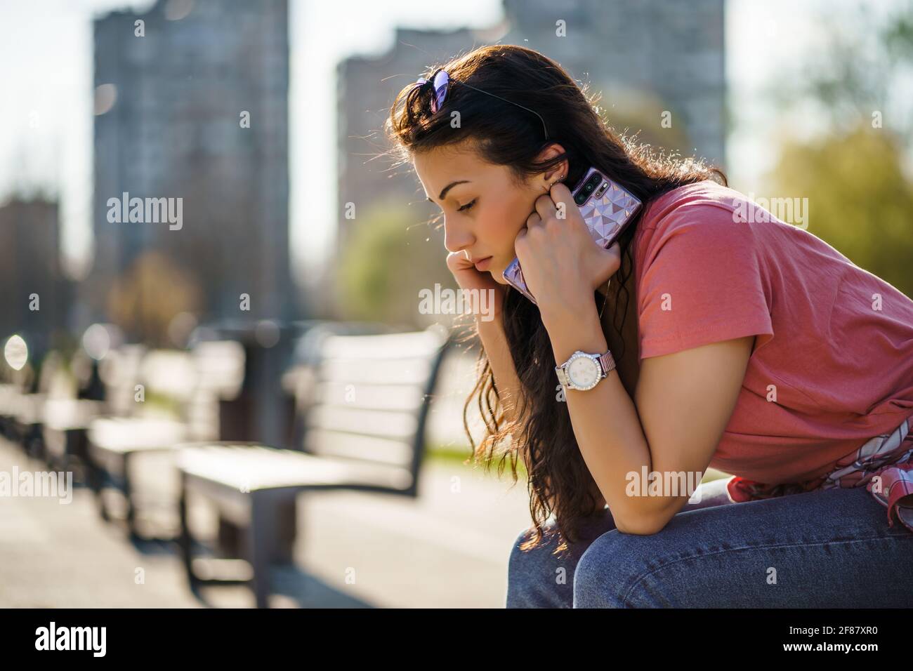 Sad young woman is sitting on bench in city. She is depressed Stock ...