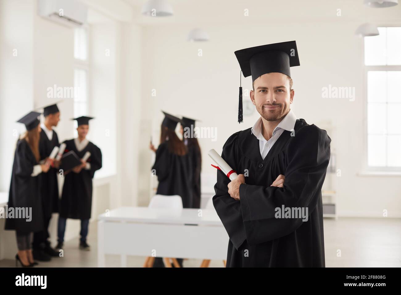 Portrait of a student in the uniform of a university graduate and with ...