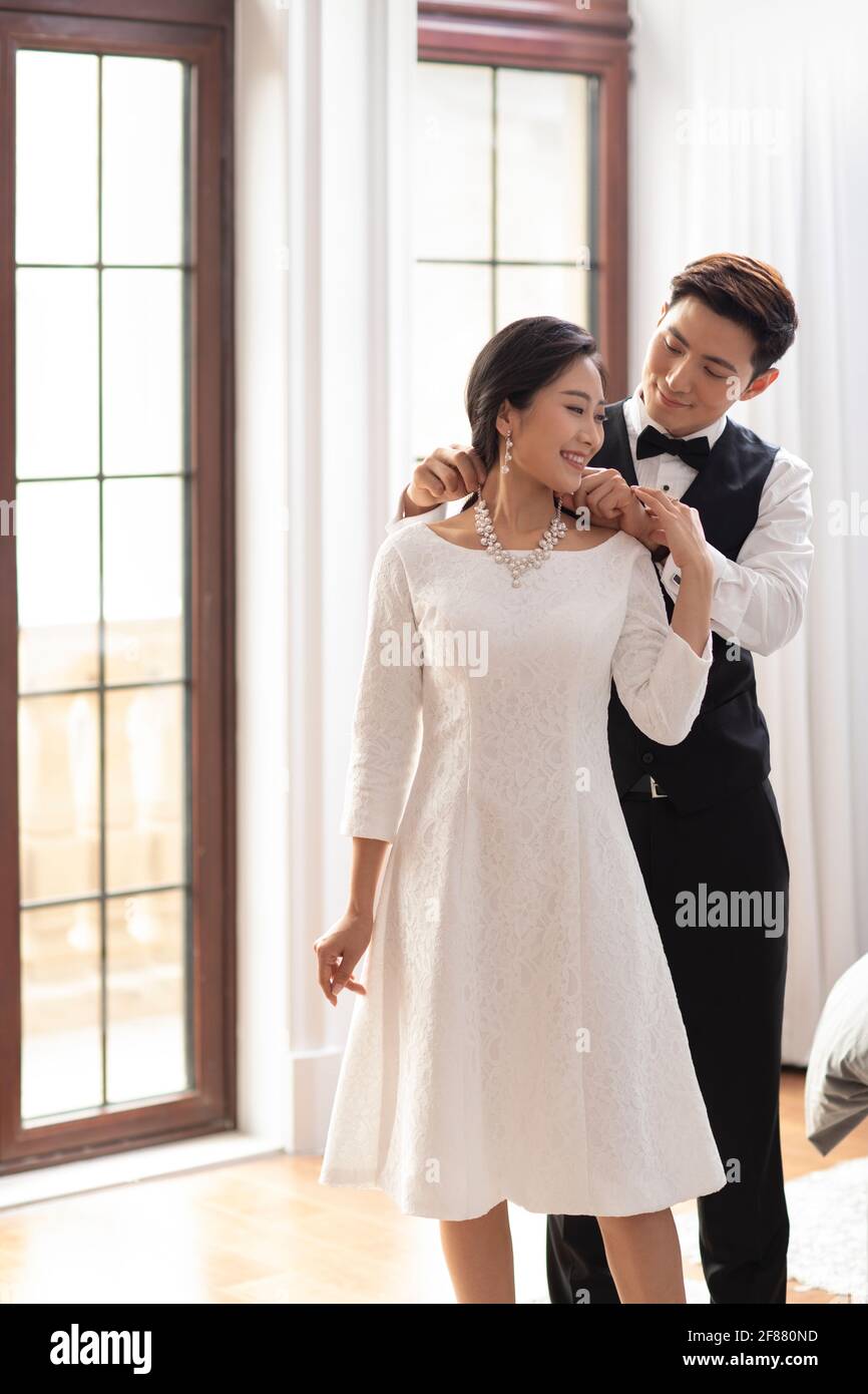 Happy young man fastening necklace for wife Stock Photo - Alamy