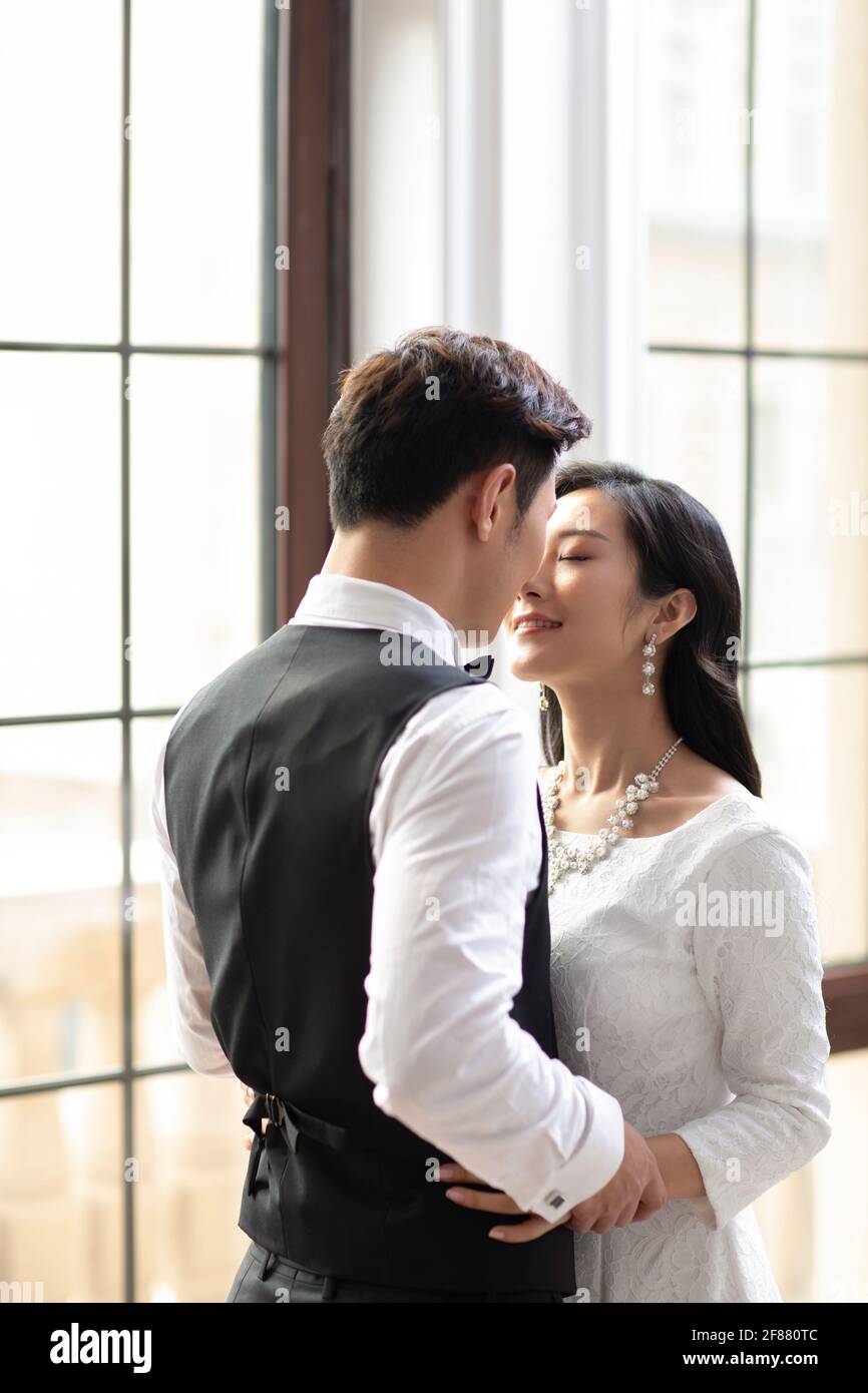 Happy young couple kissing at home Stock Photo - Alamy