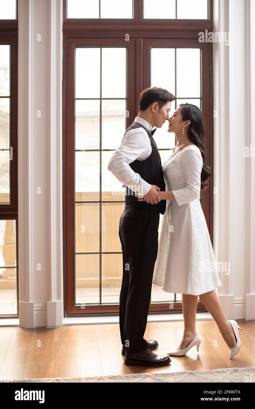 Happy young couple kissing at home Stock Photo - Alamy