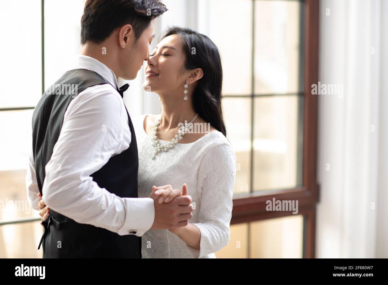 Happy young couple kissing at home Stock Photo - Alamy