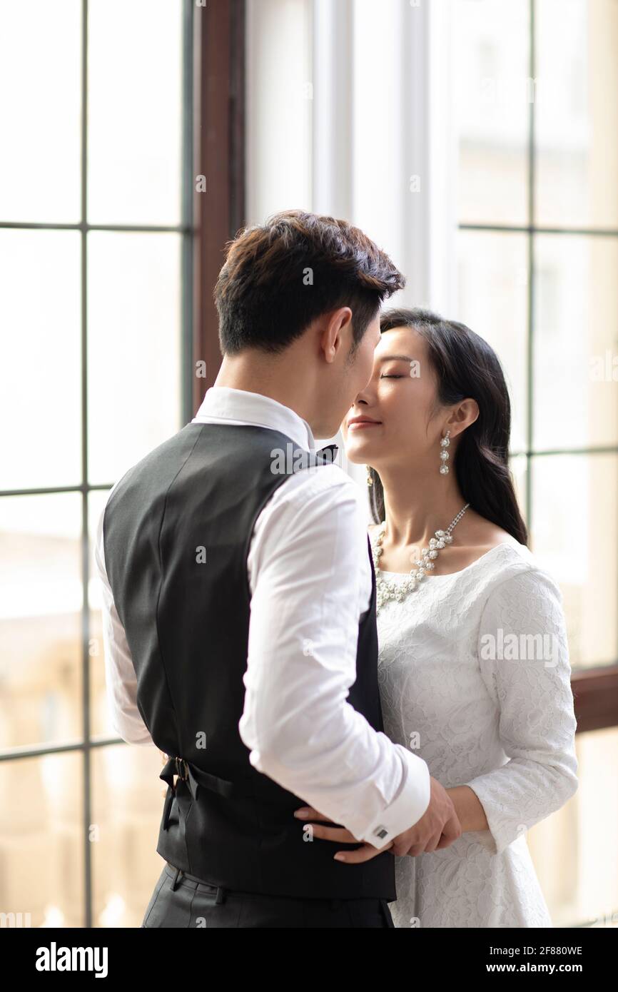 Happy young couple kissing at home Stock Photo - Alamy