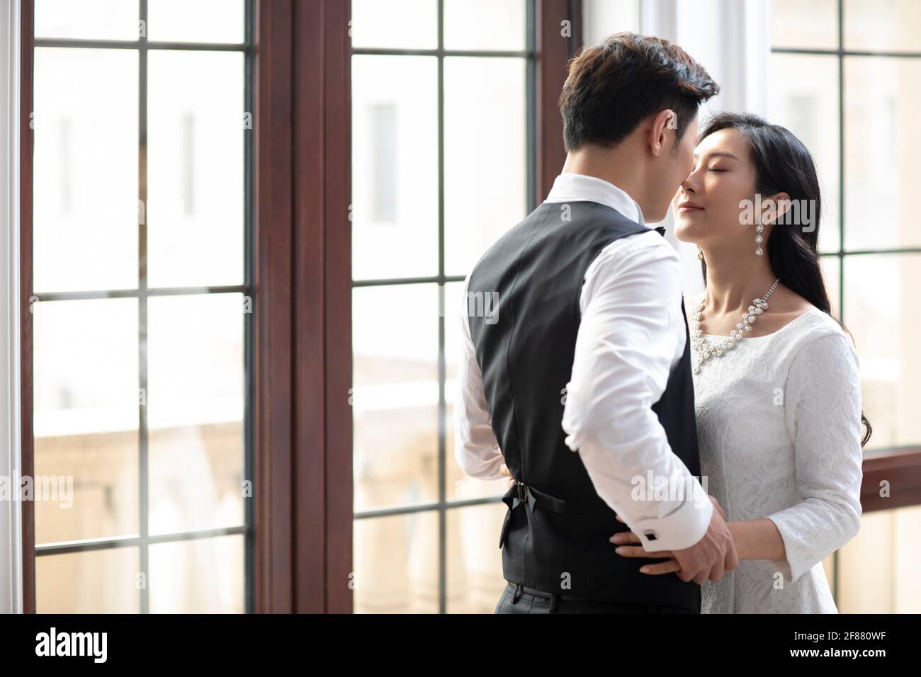Happy young couple kissing at home Stock Photo - Alamy