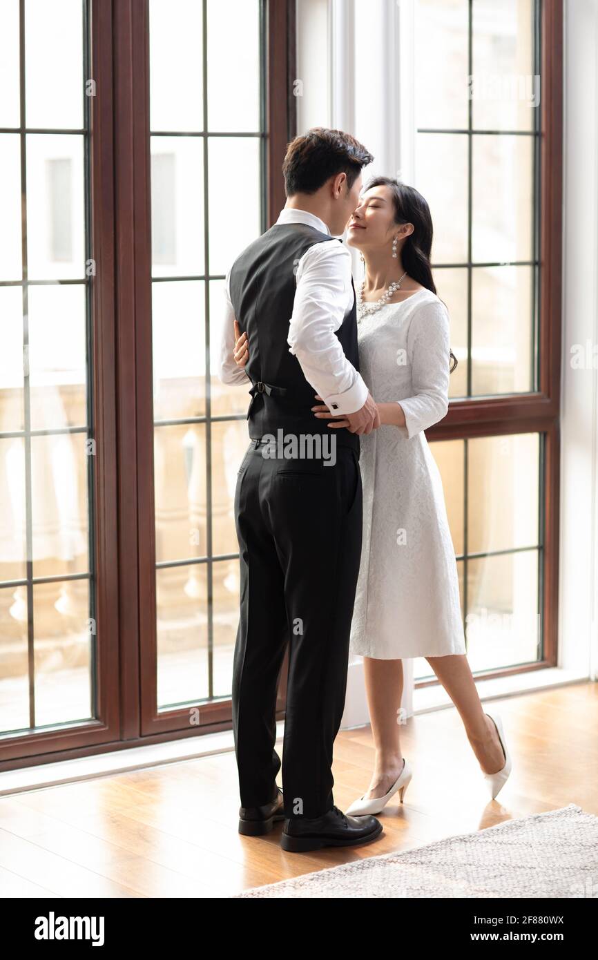 Happy young couple kissing at home Stock Photo - Alamy