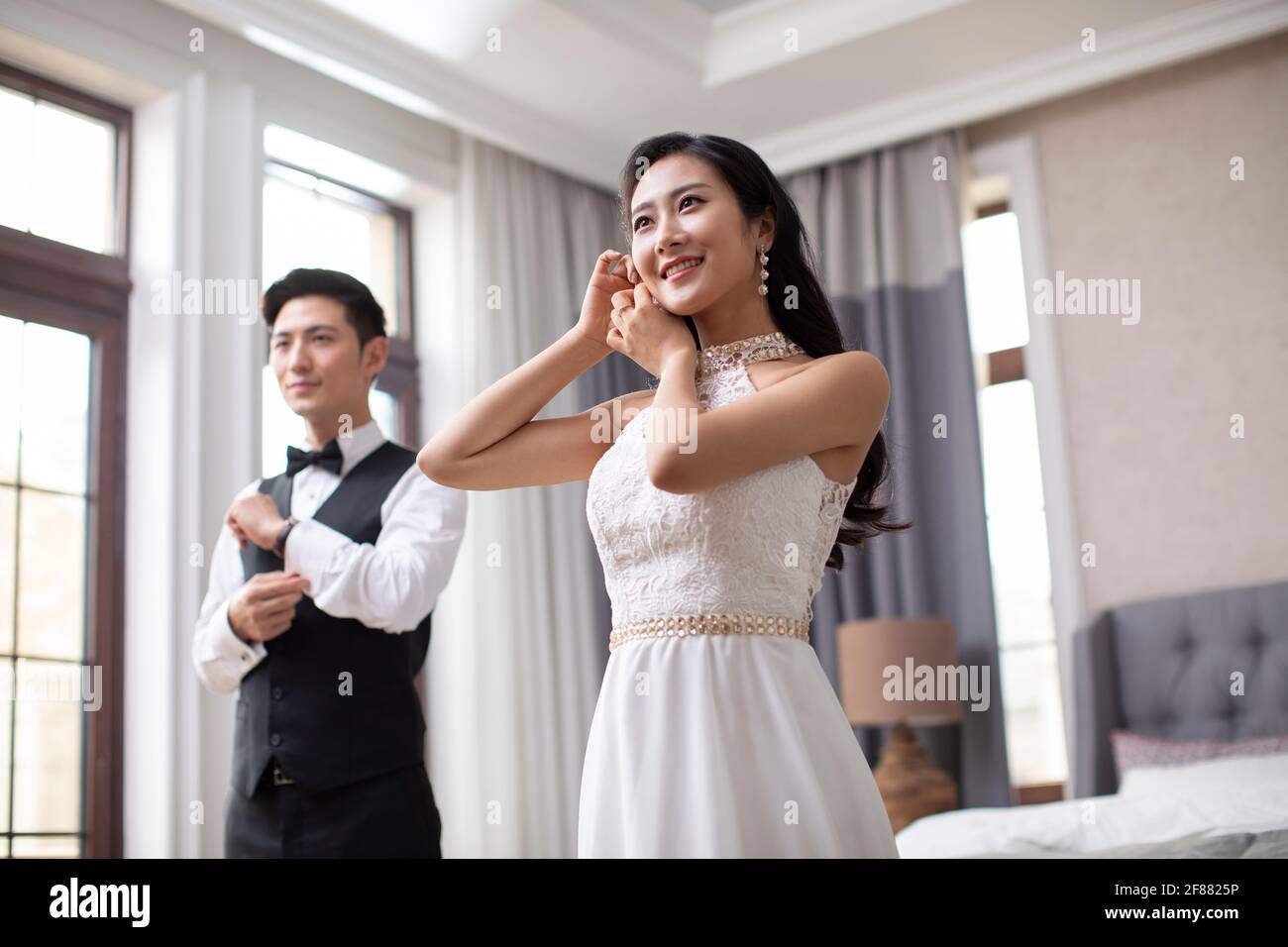 Happy young couple getting dressed at home Stock Photo - Alamy