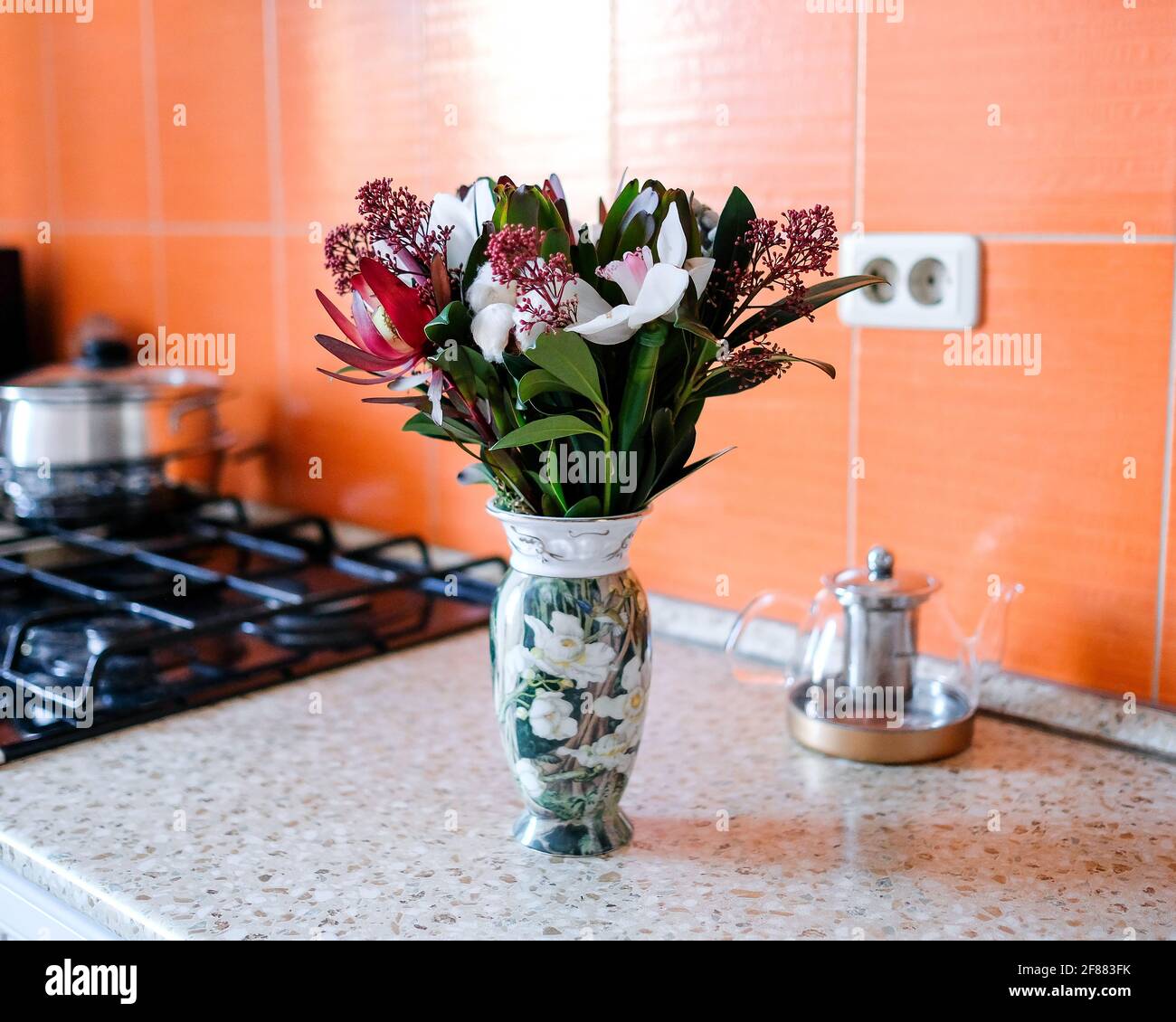 An interesting bouquet in a vase in the kitchen. Blurred background ...