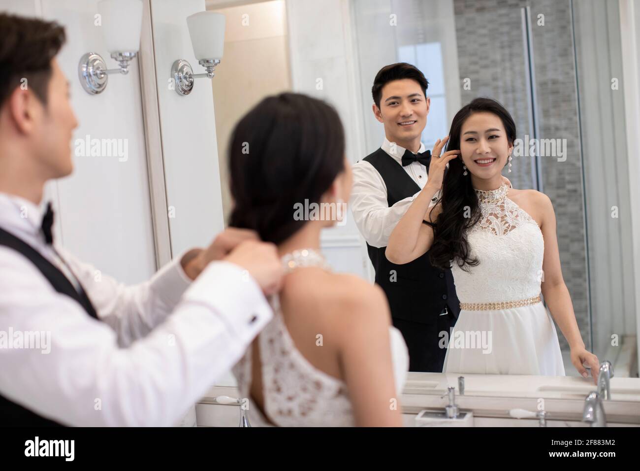 Happy young couple getting dressed in bathroom Stock Photo - Alamy