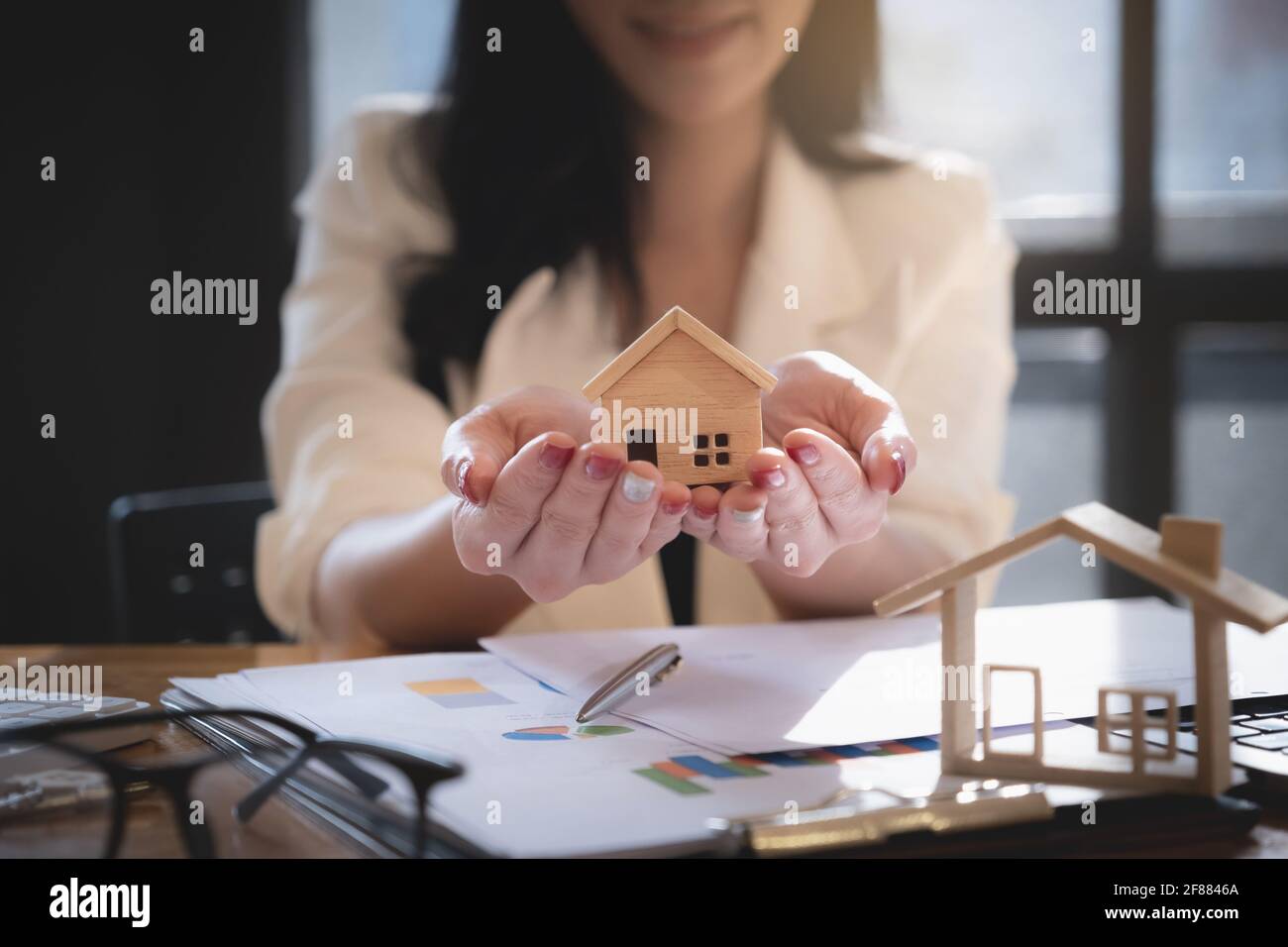 Insurance agent protecting wooden model of the house. Property ...