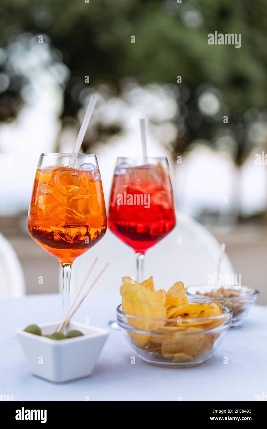 Two refreshing Italian cocktails with snacks on the table (Vertical ...