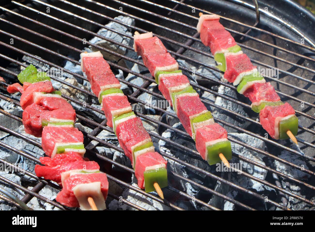 Beef brochette on the rack of a barbecue Stock Photo - Alamy
