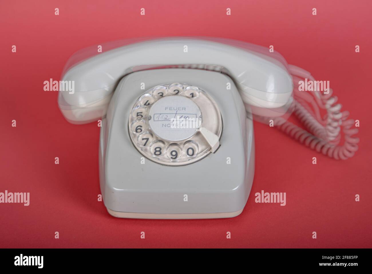 old grey telephone with dial plate, shaking receiver as symbol for ...