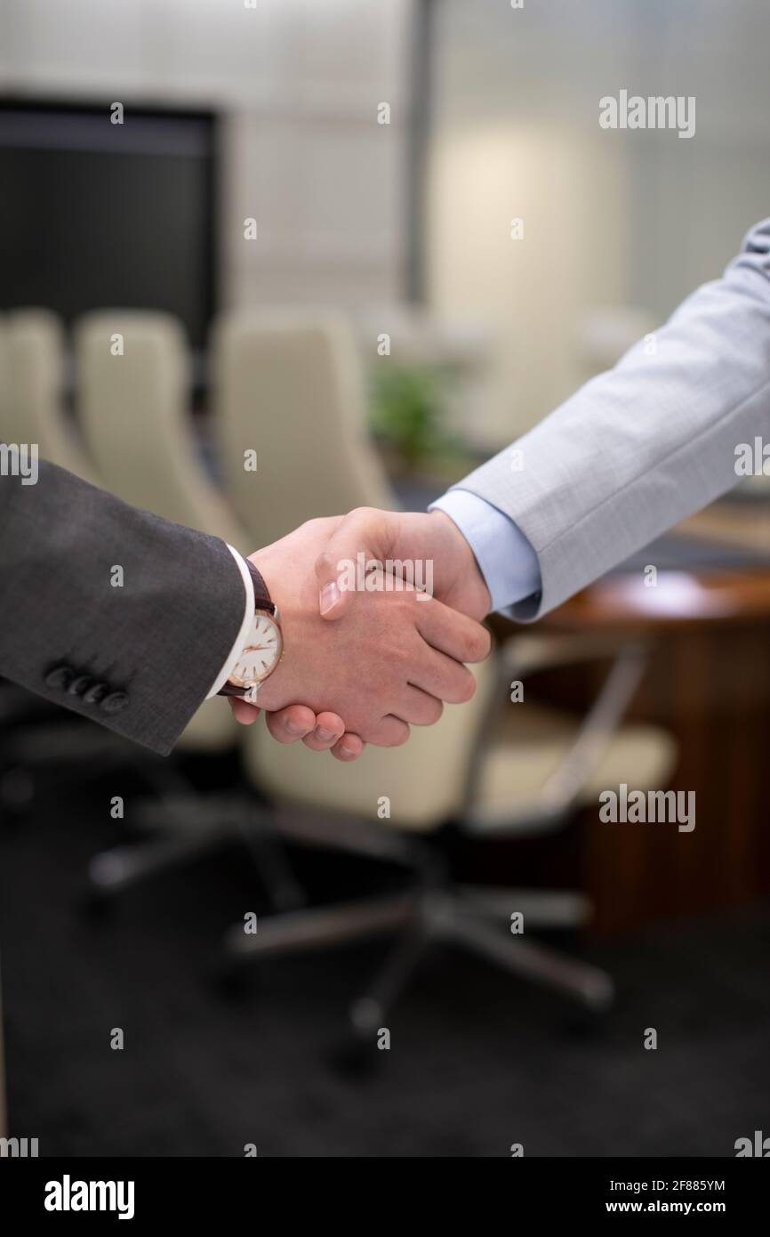 Standing shaking hands looking away smiling greeting hi-res stock ...