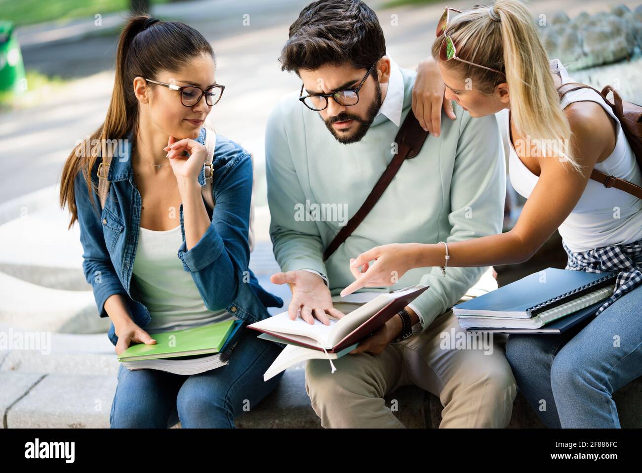 Group of friends, university students smiling, preparing for exam ...