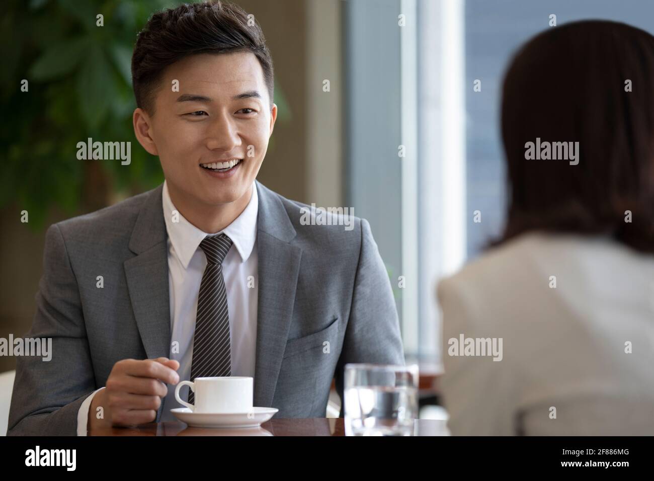 Confident business people talking in coffee shop Stock Photo - Alamy