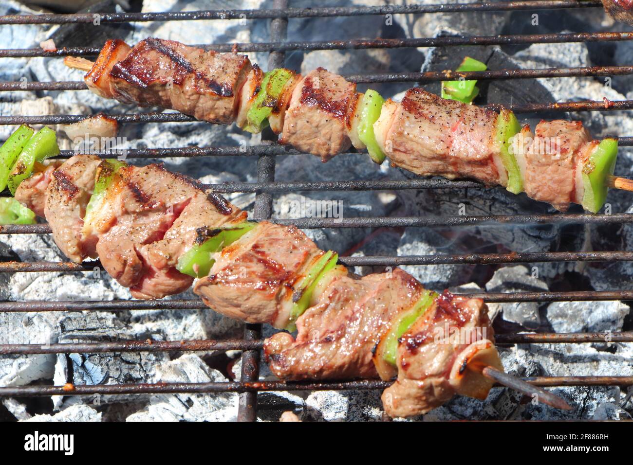 Beef brochettes on the grid of a barbecue Stock Photo - Alamy