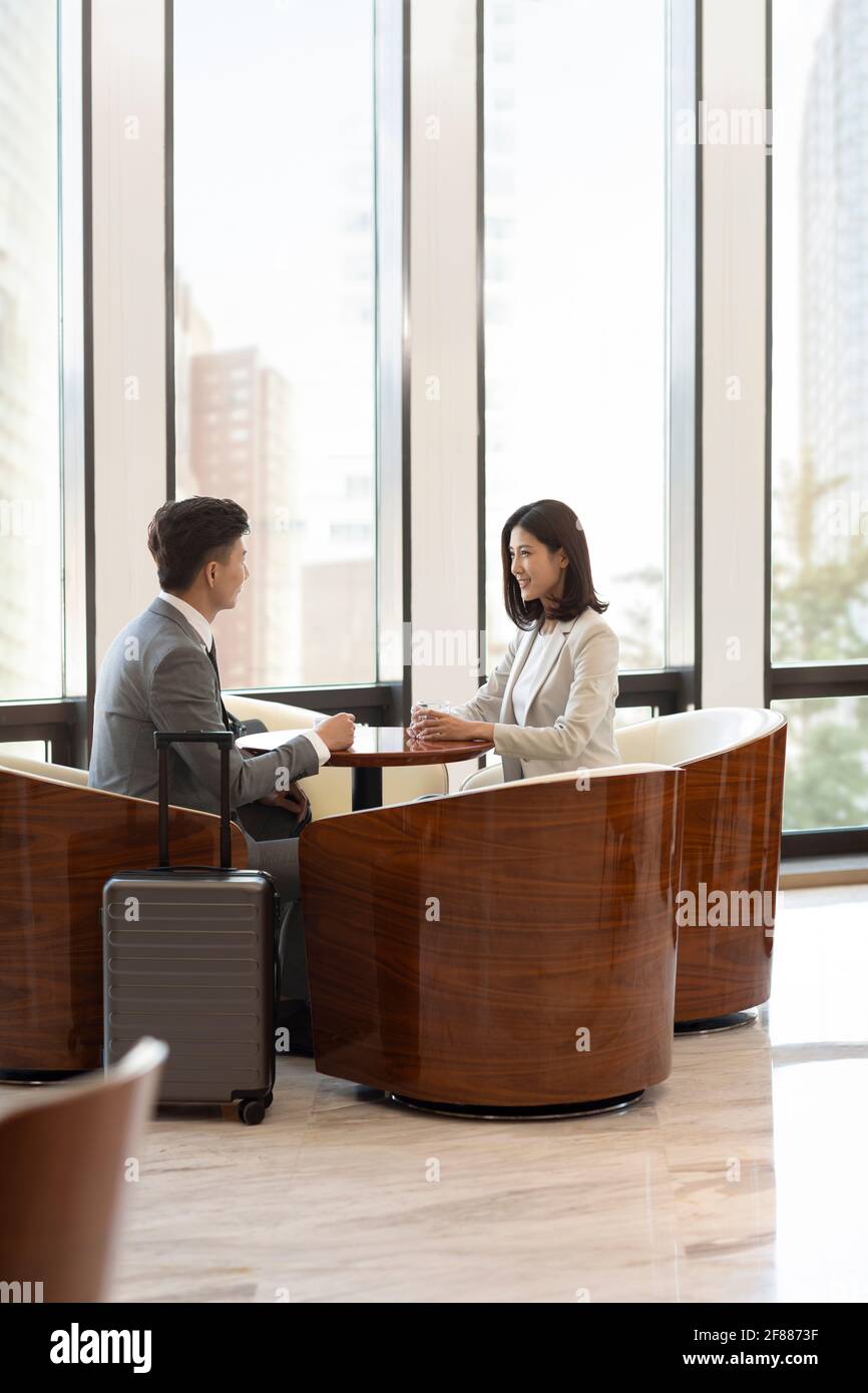 Confident business people talking in airport lounge Stock Photo - Alamy