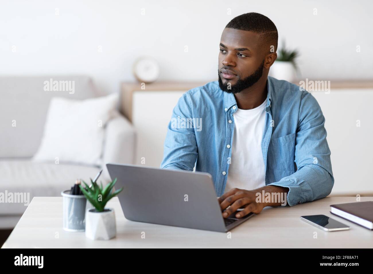 Serious handsome freelancer in black hi-res stock photography and ...