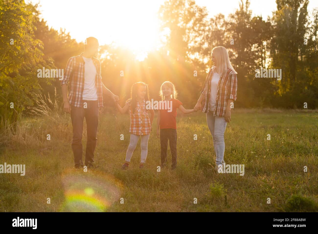 Happy family on sunset in nature Stock Photo - Alamy