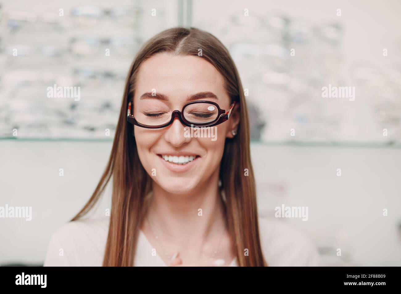 Young beautiful model woman with glasses for makeup in Optician ...