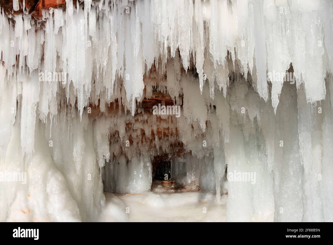 Icicles framing ice cave with red stone on Apostle Islands, Wisconsin ...