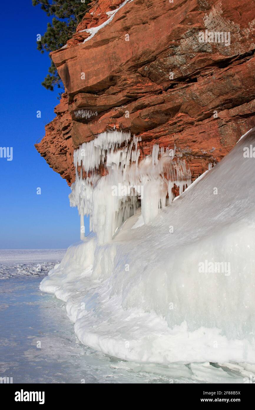 Frozen icicles and snow on red cliffs against blue sky on Apostle Islands, Wisconsin Stock Photo ...