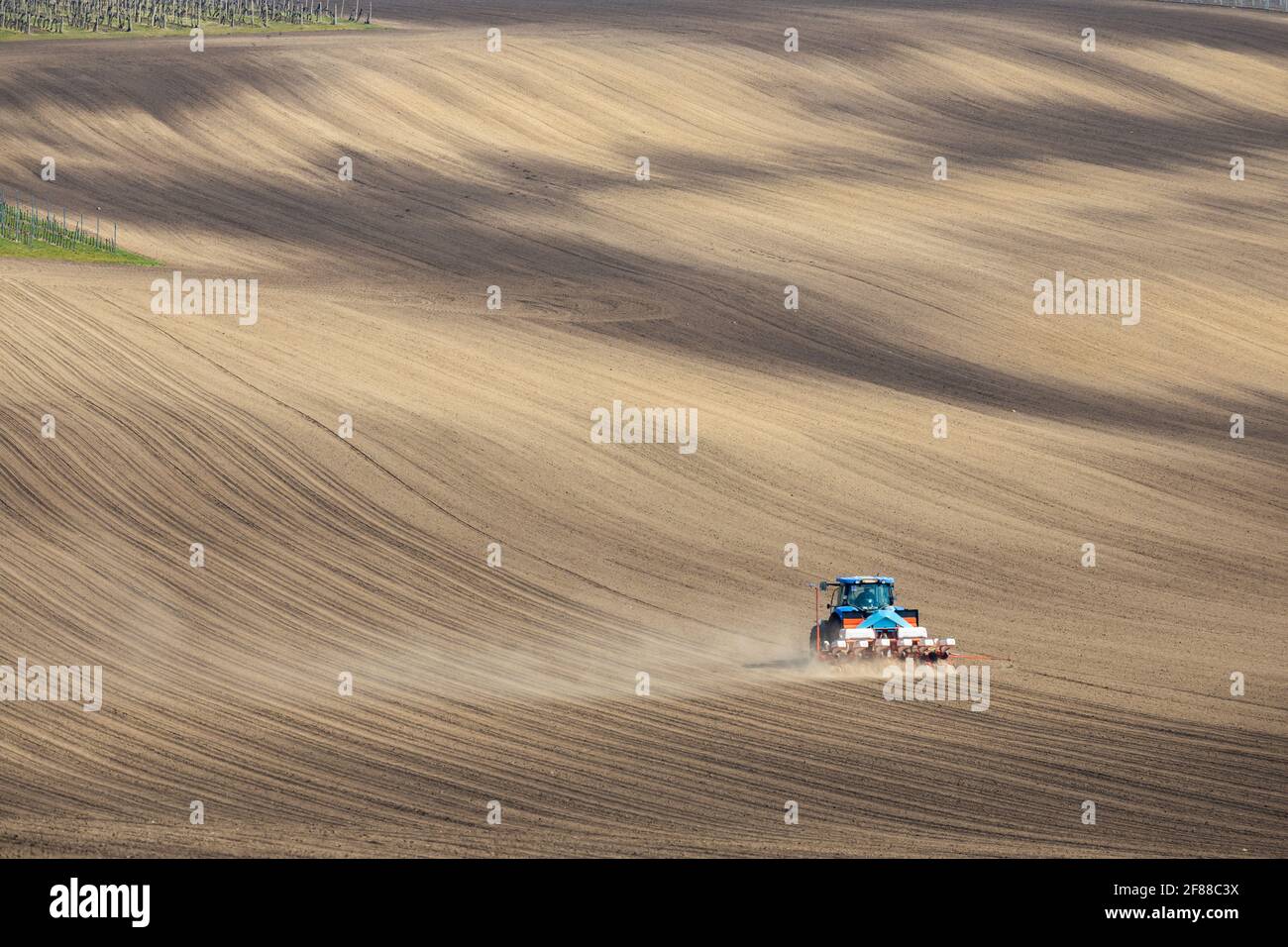 Tractor with seed drill in early spring landscape Stock Photo - Alamy