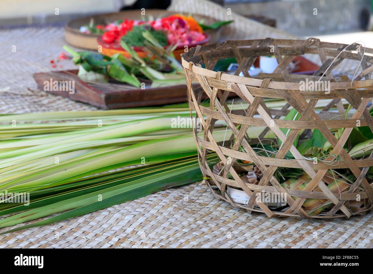 Woven basket and green banana leaf and flowers for making canang sari ...