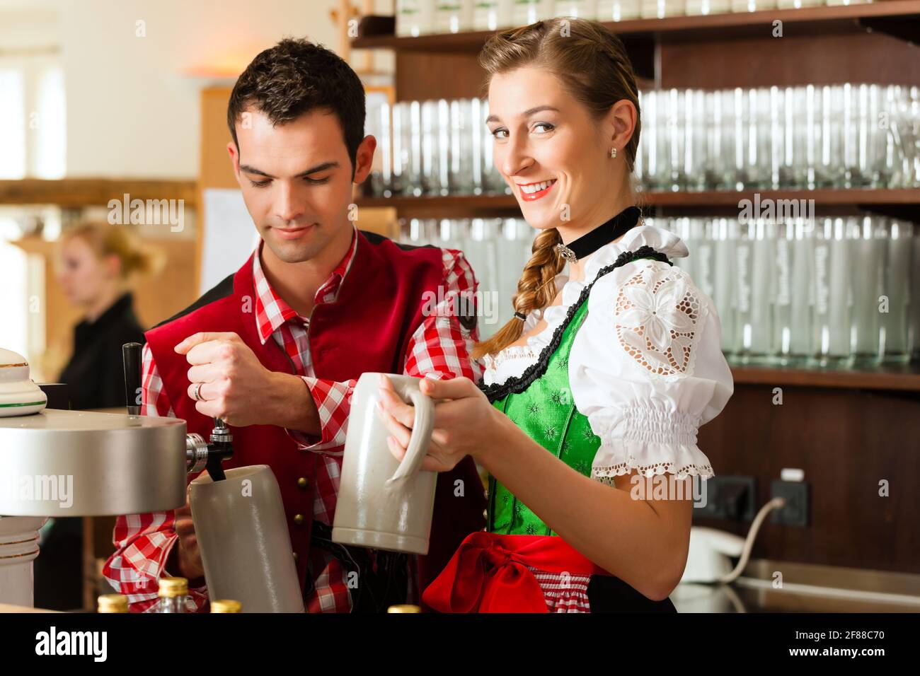 Young man drawing beer in restaurant or pub, he is the innkeeper Stock ...