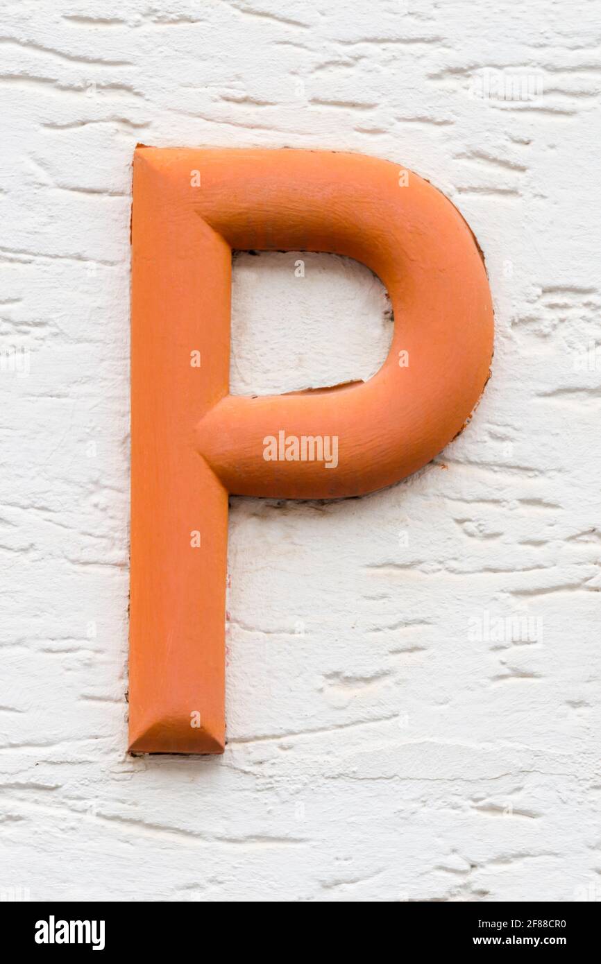 Orange letter P on a white house wall Stock Photo - Alamy