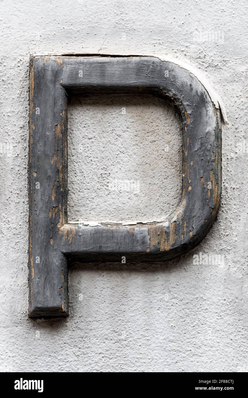 Wooden letter P with peeling black paint Stock Photo - Alamy