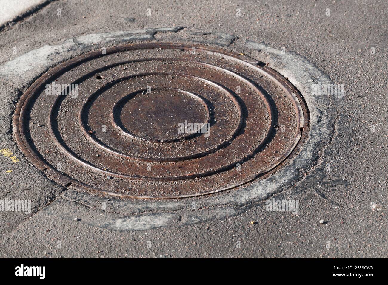 Round sewer manhole hatch is in urban asphalt road Stock Photo - Alamy