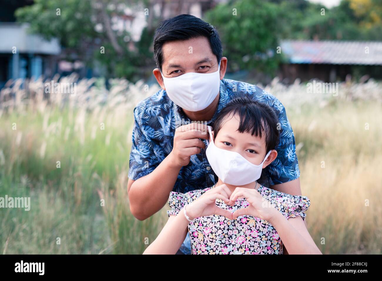 Father help his daughter wearing medical mask for protect covid-19 and ...