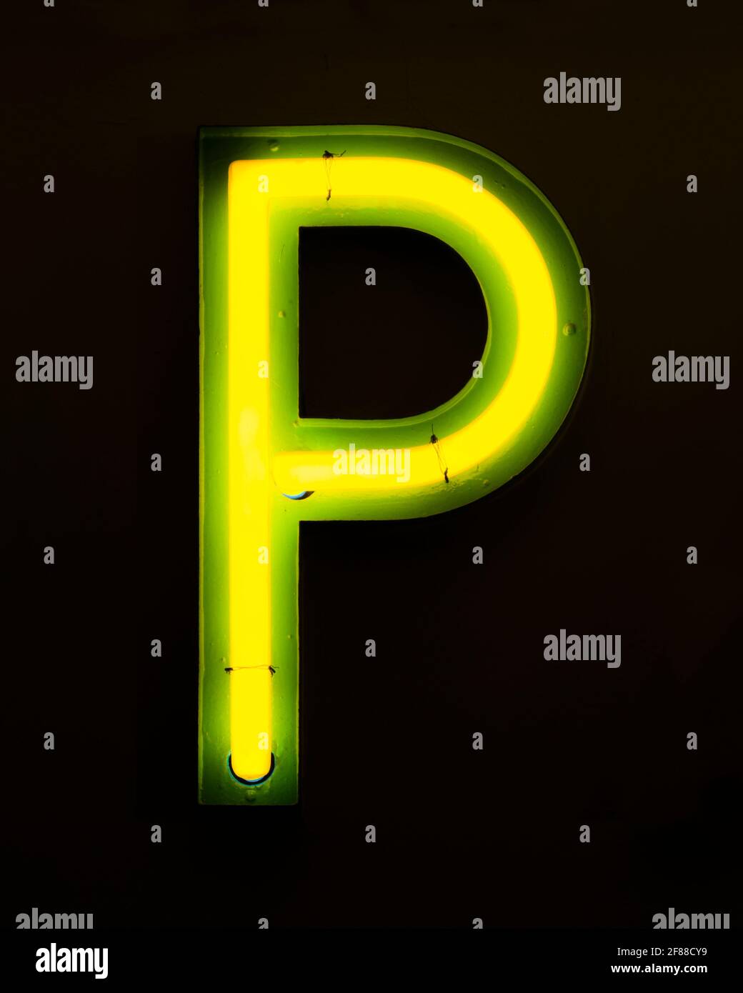 Yellow neon letter P glowing in the dark Stock Photo - Alamy