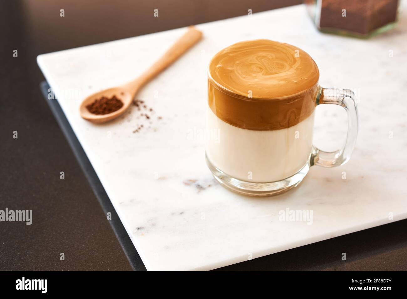 Dalgona coffee, fluffy creamy shake coffee in a transparent glass on a ...