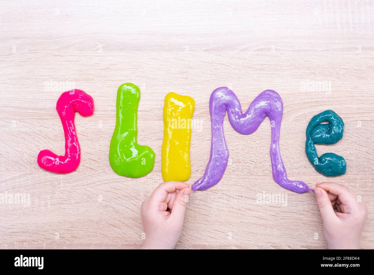 The word slime made from multi-colored slimes on a wooden table. Slime ...