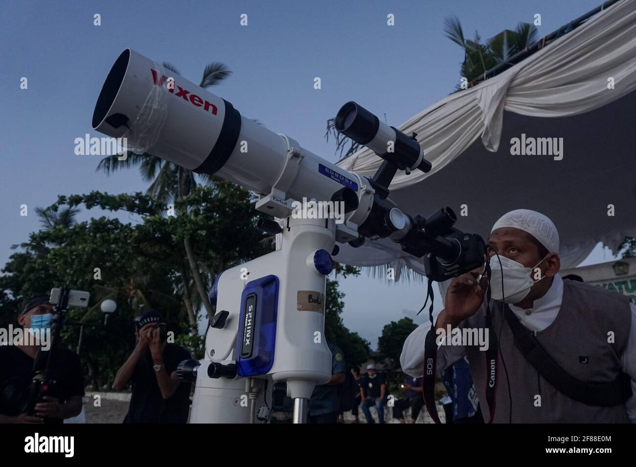 Badung, Bali, Indonesia. 12th Apr, 2021. A man observes the hilal with ...