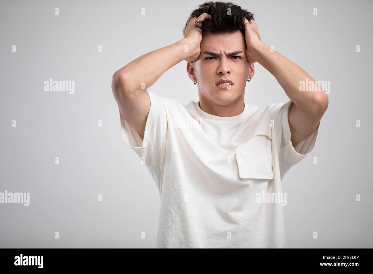 Young man scratching head Stock Photo - Alamy