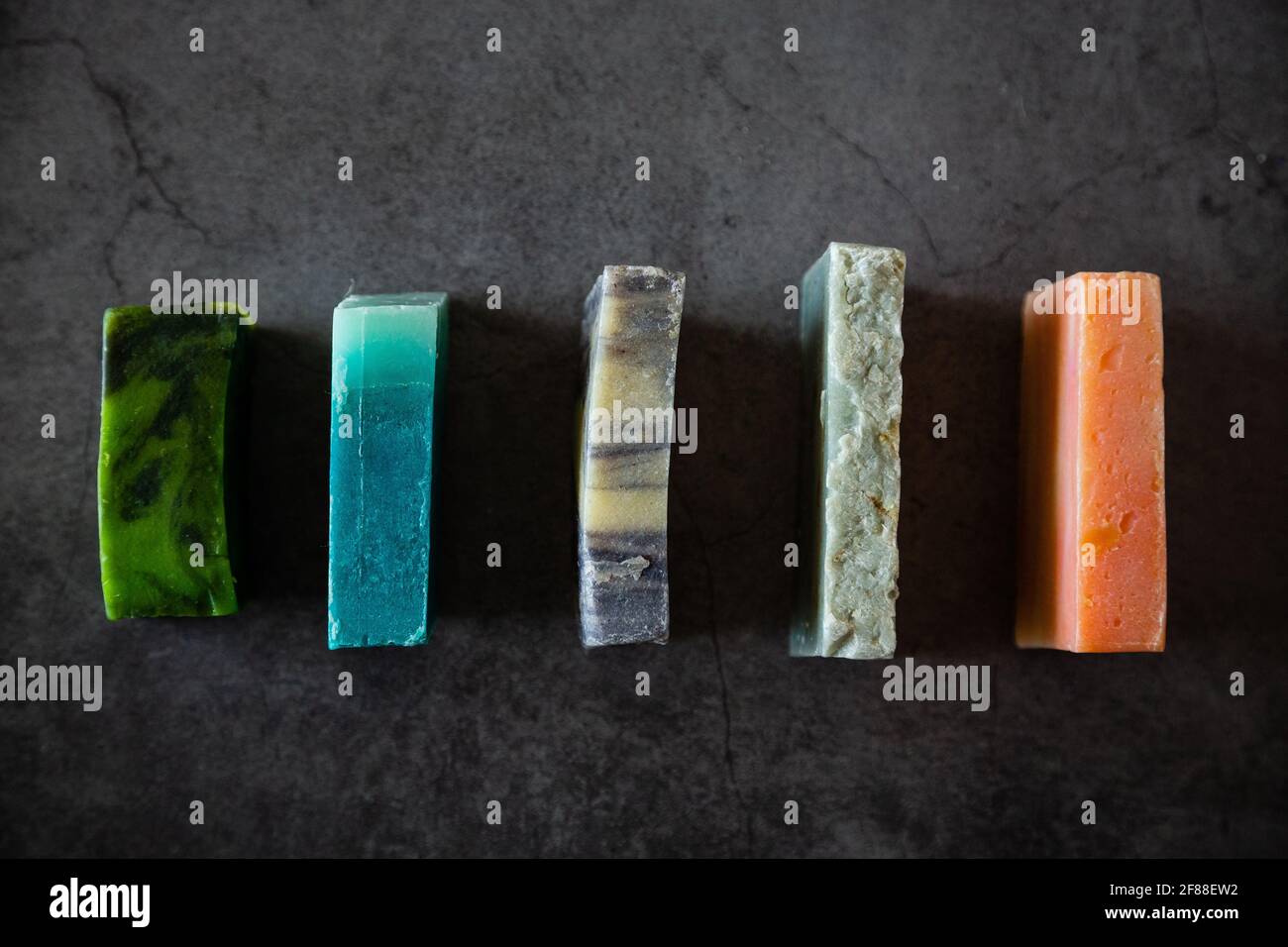 Lay flat of line of natural hand made soap bars. Dark background ...