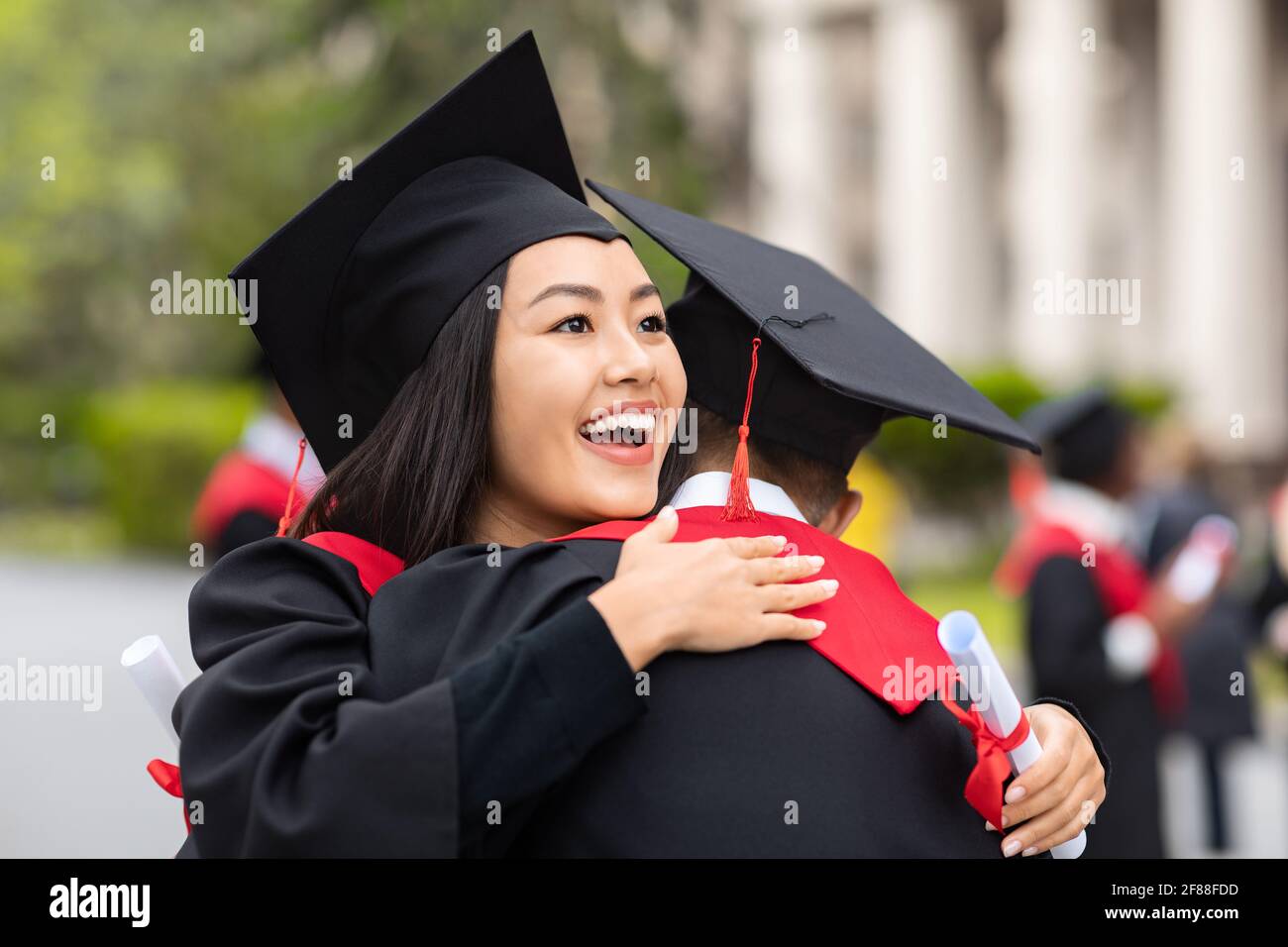 Cheerful asian lady hugging her boyfriend while graduation ceremony ... Cheerful asian lady hugging her boyfriend while graduation ceremony ...